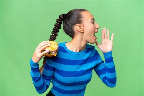 Premium Photo Young Arab Woman Holding A Burger Over Isolated