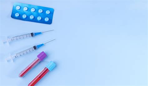 혈액 검사 정제 및 주사기를 가진 테스트 튜브는 파란색 배경에 의약품을 사용합니다 분석 결과에 따른 치료 개념 0명에 대한 스톡