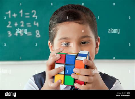 Close Up Of Girl Solving Rubik Cube In A Classroom Stock Photo Alamy
