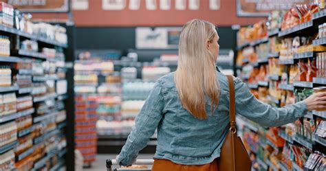 소매 판매 상점에서 재료 요리 제품 또는 건강 식품에 대한 고객 등 및 식료품 쇼핑 카트 뒤에 쇼핑몰 승진 또는 식료품 거래를 위한 슈퍼마켓에 있는 여자와 소비자 트롤리