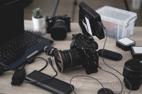 디지털 카메라 플래시 클리닝 키트 메모리 카드 삼각대 및 블랙 테이블 배경카메라 액세서리를 갖춘 작업 공간 사진작가의 최고 보기