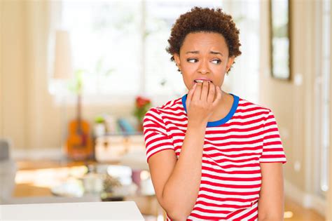 젊은 아름 다운 아프리카 계 미국인 여자 집에서 보고 스트레스와 긴장 으로 손 에 입 물고 손톱 불안 문제 T 셔츠에 대한 스톡 사진 및 기타 이미지 Istock