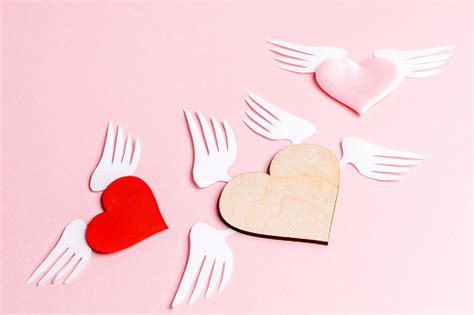발렌타인 데이 개념 분홍색 파스텔 배경 위에 종이 접기 천사 날개와 심장 사랑의 감정 배경 0명에 대한 스톡 사진 및 기타