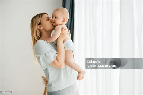 Photo Libre De Droit De Mère Aimante Embrassant Son Bébé Tout En