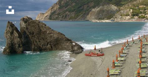 바다 옆에 잔디 의자가 많이 놓인 해변 사진 Unsplash의 무료 바닷가 이미지