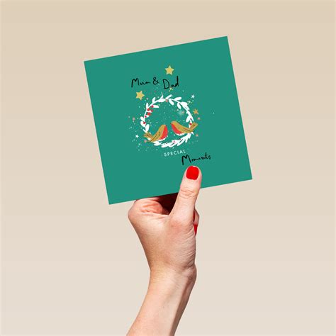Personalised Mum And Dad Illustrated Robins And Wreath Christmas Card