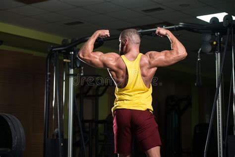 Portrait Of A Healthy Young Caucasian Man Posing In The Gym And Flexing