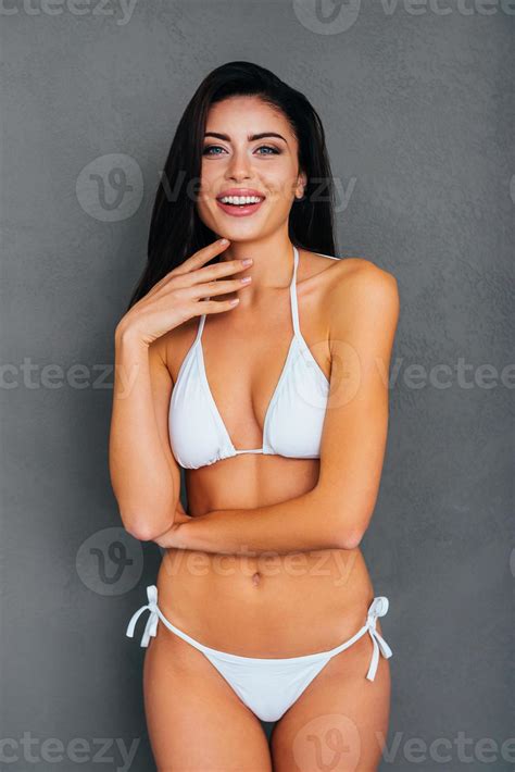Fresh And Beautiful Attractive Young Smiling Woman In White Bikini Posing Against Grey