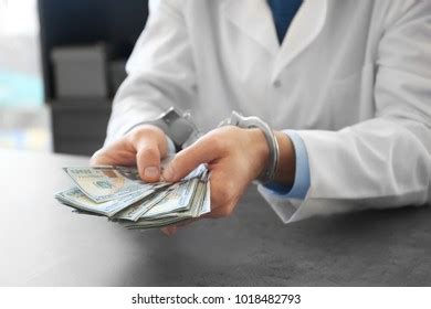 Doctor Handcuffs Holding Bribe Workplace Closeup Stock Photo 1018482793