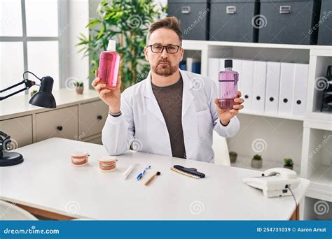 Middle Age Caucasian Dentist Man Holding Mouthwash For Fresh Breath