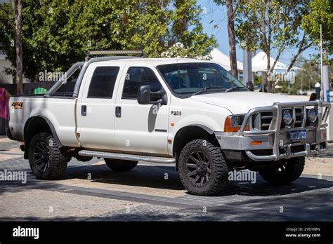 A White Ford F250xlt 4x4 Utility Vehicle With A Bull Bar Parked