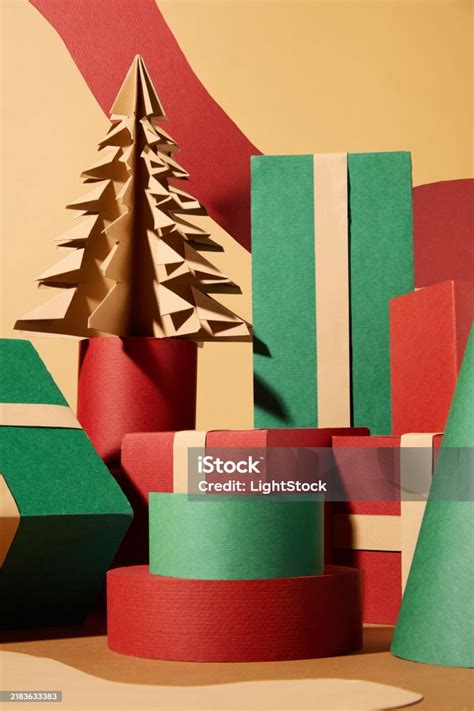 베이지색 배경의 전면 사진은 빨간색 원형 플랫폼에 제품 디스플레이를 위한 녹색 원형 플랫폼을 보여줍니다 쌓인 선물 상자 원뿔 종이 소나무 빨간 종이 조각으로 둘러싸여