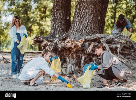 Group Of Activists Friends Collecting Plastic Waste On The Beach
