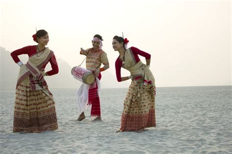 Bihu Women Dancing As Bihu Man Plays On A Dhol Photo Background And