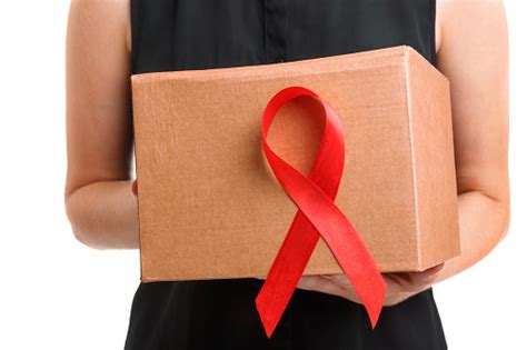 상자에 빨간 리본입니다 여자는 흰색 배경에 고립 된 에이즈 인식 기호를 들고 의료 자선 개념입니다 공단에 대한 스톡 사진 및