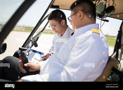 Chinese Pilot Teaching Trainee To Operate Control Panel In Cockpit