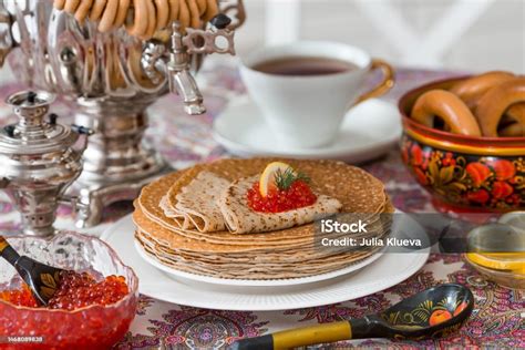 러시아 전통 러시아 휴일 마슬레니차 차 한잔 팬케이크 더미 빨간 캐 비어 레몬 베이글 막대 사탕 수탉 나무 숟가락 및 사모바르가있는 정물 0명에 대한 스톡 사진 및 기타