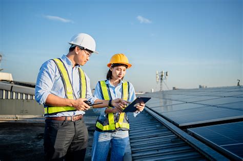 함께 일하는 두 명의 전기 엔지니어는 디지털 태블릿을 사용하여 태양광 발전소 재생 에너지 지속 가능한 비즈니스 개념에 태양 전지판의 설치 및 유지 관리를 검사합니다 25