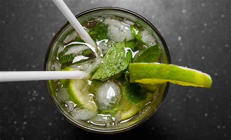 Unalcohol Mohito 라임과 민트와 함께 칵테일의 근접 촬영 유리 배경 바에서 두 개의 튜브와 석 회의 조각으로 장식