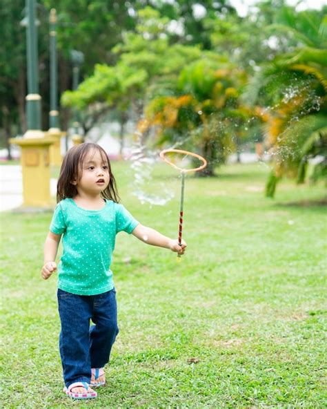 La Longitud Completa De La Chica Jugando Con Burbujas En El Parque