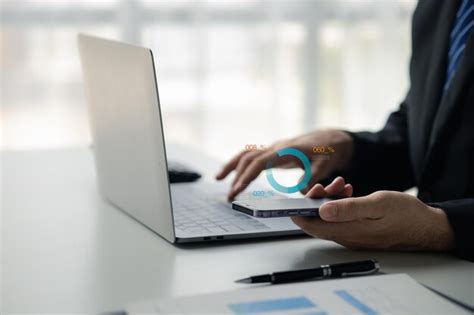 계산을 위해 재무 데이터를 보여주는 홀로그램 그래프와 함께 휴대폰을 들고 있는 사업가는 회사 재무 개념을 성장시키는 방법을 계획하기 위해 과거 재무 데이터를 분석하고