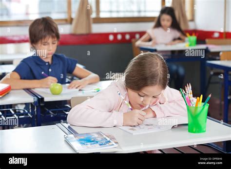 Babegirl Drawing While Leaning On Desk In Classroom Stock Photo Alamy