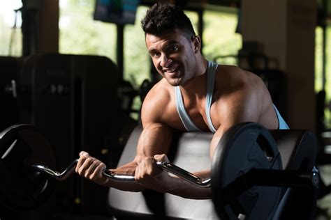Ejercicio de bíceps con barra en un gimnasio Foto Premium