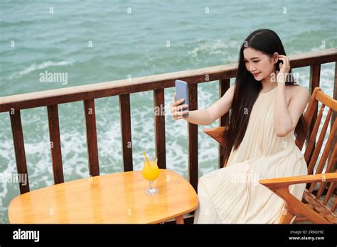 Young Woman Tucking Hair Behind Her Ear When Taking Selfie At Spa