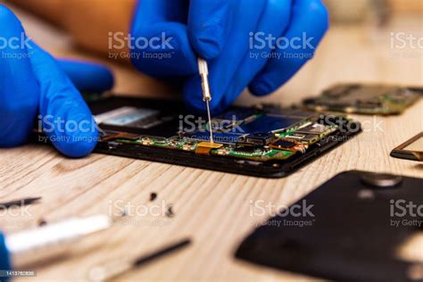 테이블 위의 작업장에서 스마트폰의 마더보드를 수리하는 기술자 Brand Name Smart Phone에 대한 스톡 사진 및 기타 이미지 Brand Name Smart