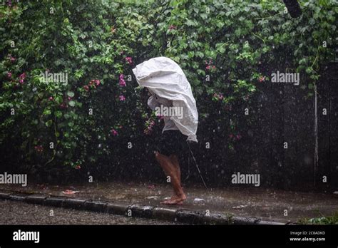 A Man Uses A Plastic Sheet To Protect Himself From The Heavy Rainheavy