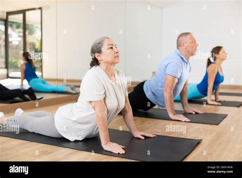 Class Of Male And Women Of Different Ages In Active Wear Doing Cobra Exercise Exercise During