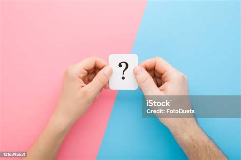 젊은 성인 남자와 여자는 함께 밝은 파란색 핑크 테이블 배경에 물음표의 흰색 카드를 들고 손을 파스텔 색상 부부 관계 문제의