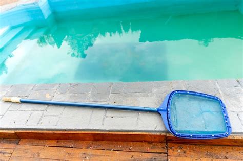 Premium Photo A Handheld Cleaner Of A Garbage Collection Net Lies On The Edge Of The Pool