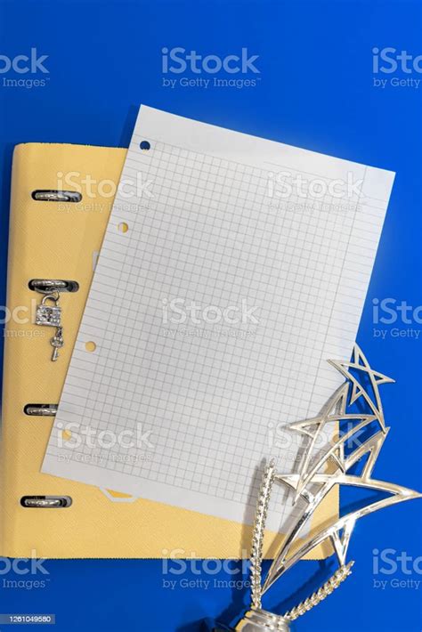 종이의 빈 시트와 노란색 메모장의 평평한 평지 파란색 배경에 황금 빛나는 별 공간을 복사합니다 승리의 개념 0명에 대한 스톡