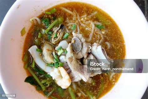 돼지 뼈 가재 새우와 매운 해산물 국수 수프 나무 테이블 배경에 분홍색 그릇에 아시아 음식입니다 태국 스타일의 국수와 태국의 길거리 음식 맨 위 보기 건강한 생활방식에 대한