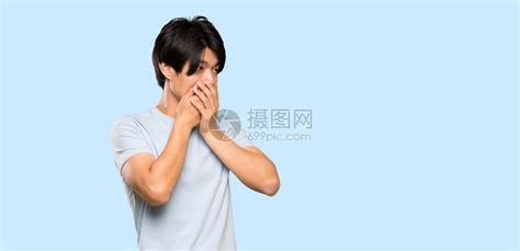 身穿蓝色衬衫捂着嘴巴在孤立的蓝色背景中望向侧高清图片下载 正版图片504433366 摄图网