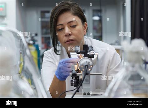 Attractive Female Scientist Testing Using Microscope To Test For Dna