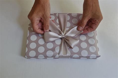Premium Photo Cropped Hand Tying Ribbon To T On Table