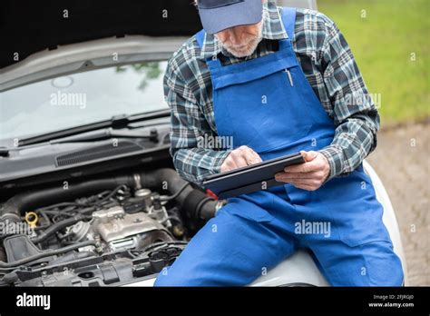 Car mechanic using digital tablet for checking car engine Stock Photo ...