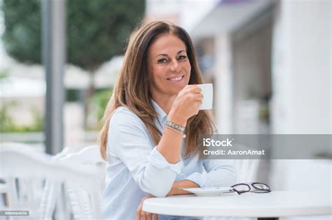 아름 다운 중세 마에 얼굴에 미소와 함께 식당에서 히스패닉 여자 자신감과 밝은 화창한 날에는 테라스에서 커피 한잔 마시는 갈색 머리에 대한 스톡 사진 및 기타 이미지