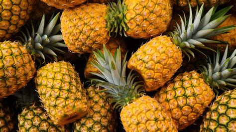 Detailed View Of A Pineapple S Textured Exterior Against A Fruit Filled