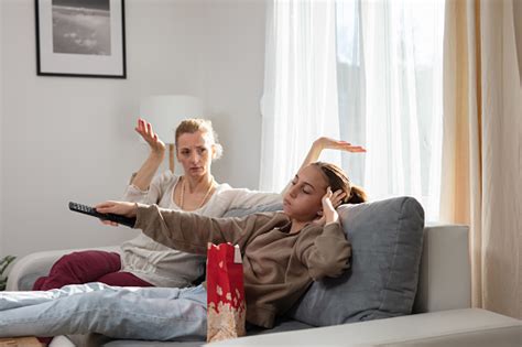 Mother Having Trouble With A Lazy Teenager Girl At Home While Watching