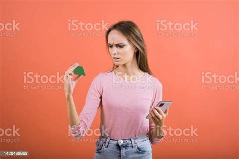 불쾌감을 느낀 소녀는 빨간색 배경에 신용 카드와 휴대 전화를 사용합니다 불쾌한에 대한 스톡 사진 및 기타 이미지 불쾌한 신용 카드 20 24세 Istock