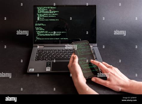 Person With Computer And Mobile Phone Hacking With The Pegasus Program