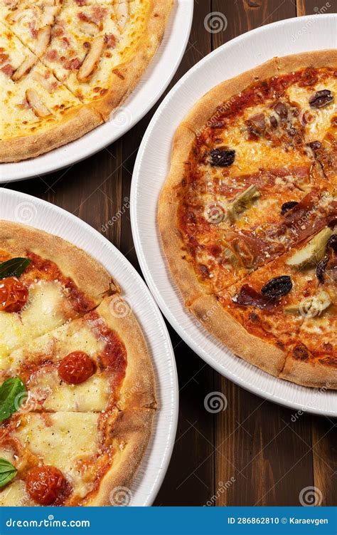 Three Different Pizzas On Wooden Background With Tomato Sauce Mixed