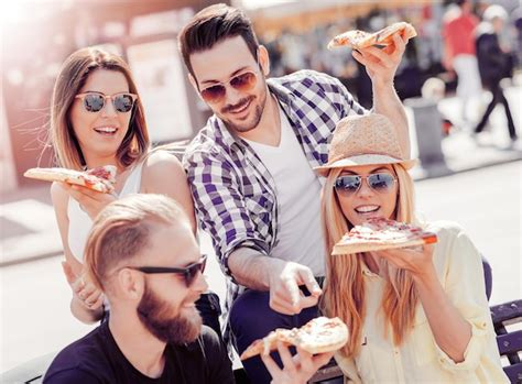 Grupo de jóvenes amigos comiendo pizza al aire libre Foto Premium