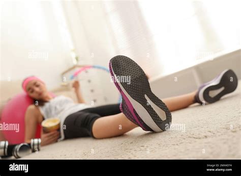 Lazy Young Woman Eating Ice Cream Instead Of Training At Home Focus On
