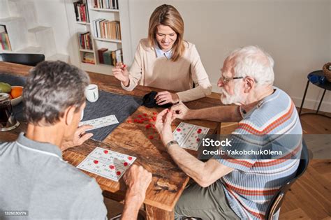 빙고 게임에서 플레이하는 동안 간병인 앞 테이블에 앉아있는 사람들 35 39세에 대한 스톡 사진 및 기타 이미지 35 39세