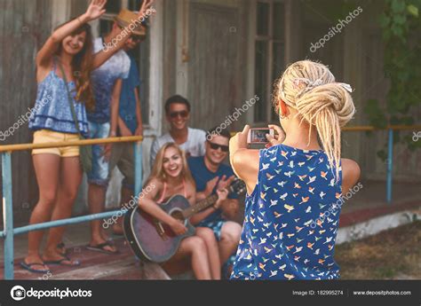 Young Blonde Girl With Dreads Takes A Photo Of A Groups Of Her Friends