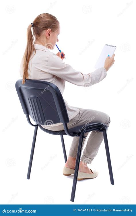 Back View Of Young Beautiful Woman Sitting On Chair And Takes Stock